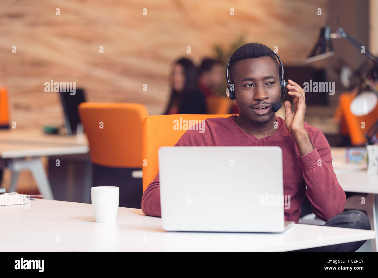 Customer Service agent in an startup office with laptop Stock Photo - Alamy