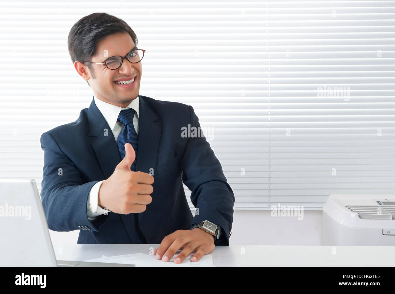 Young professional man in happy mood showing thumbs up sign and winking ...