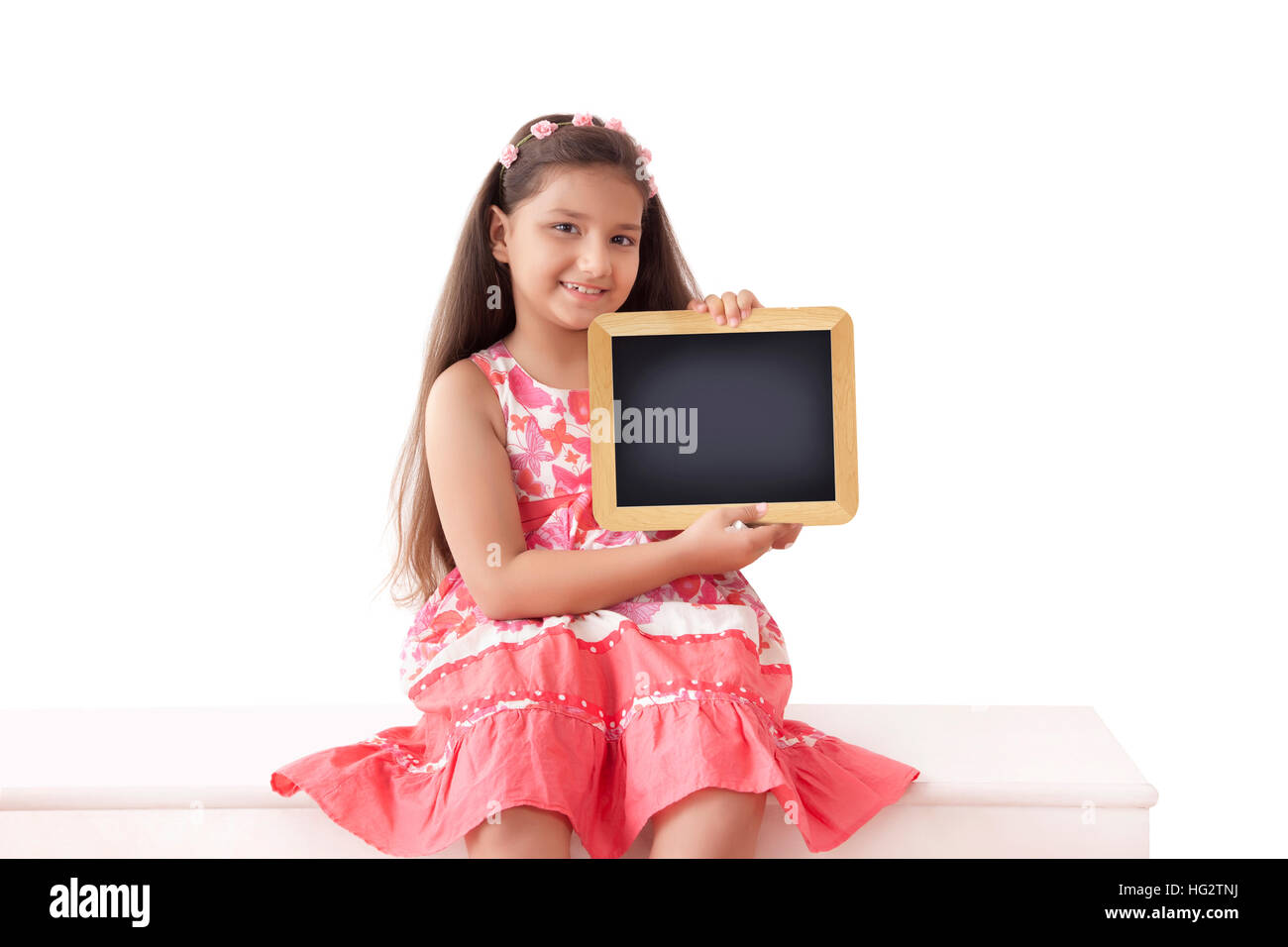 Girl smiling and holding slate Stock Photo - Alamy