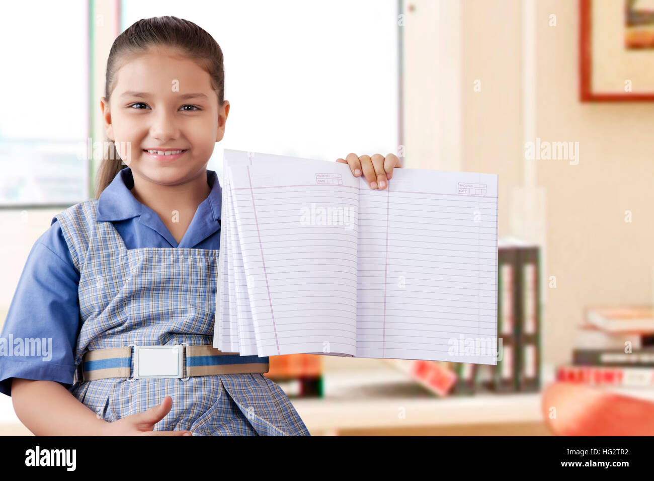 Girl in school uniform showing her homework Stock Photo - Alamy