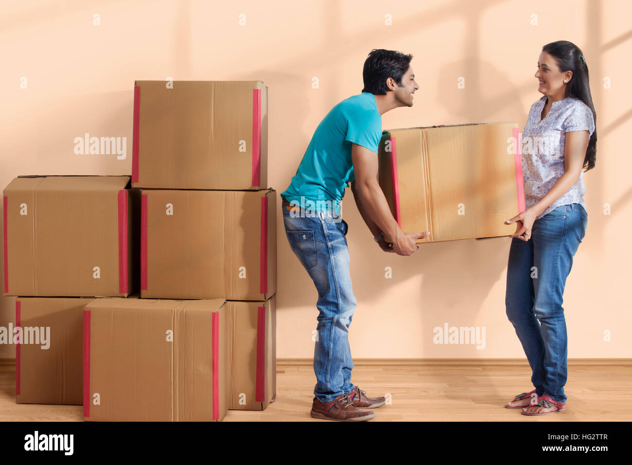 Couple hauling cardboard boxes in new house Stock Photo - Alamy