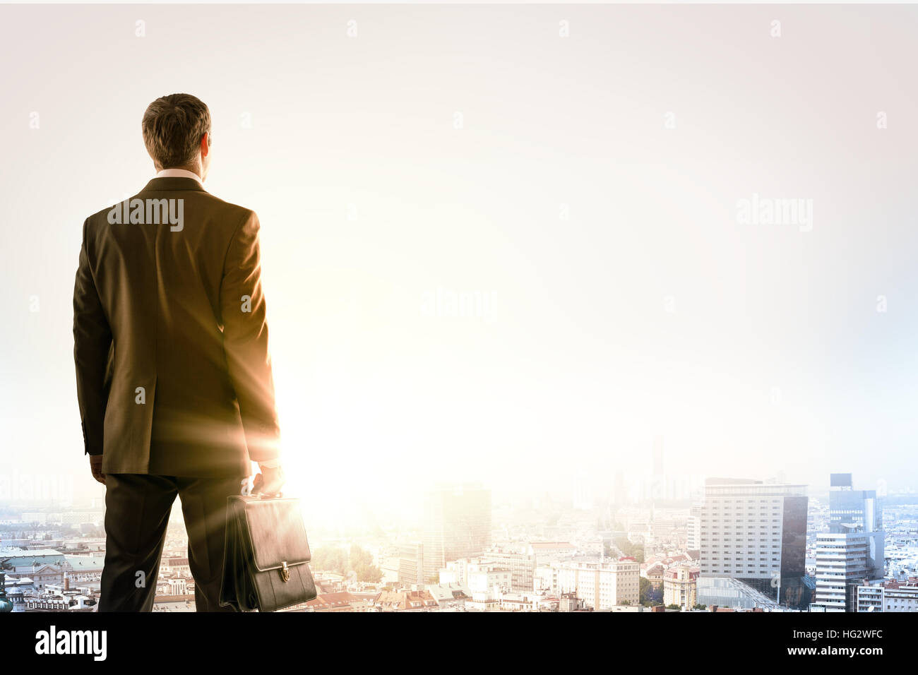 Businessman standing with back against city Stock Photo - Alamy