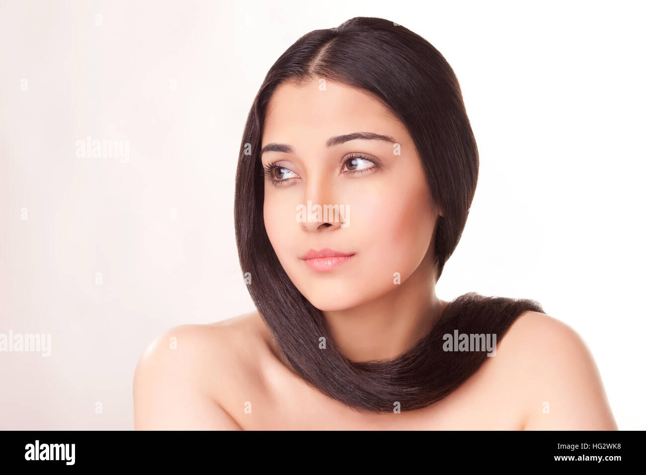 Portrait of beautiful young woman with long hair wrapped around neck ...