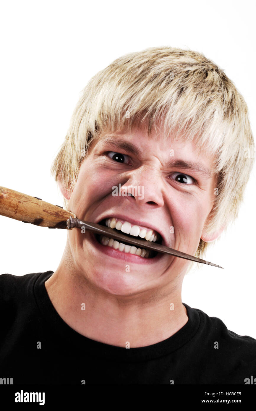 Young man with knife between his teeth Stock Photo - Alamy