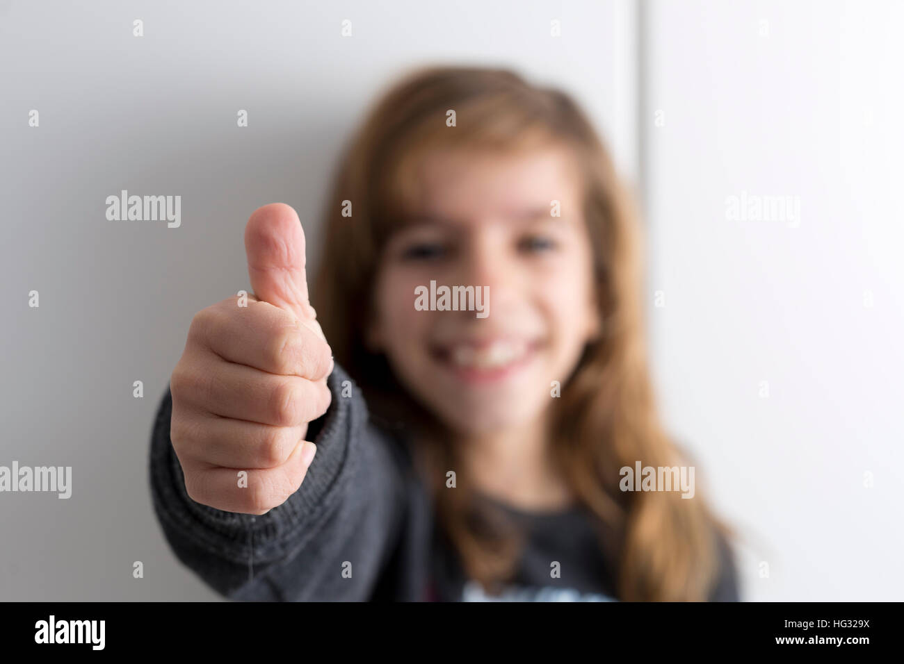 Girl with thumb up and her face out of focus Stock Photo - Alamy