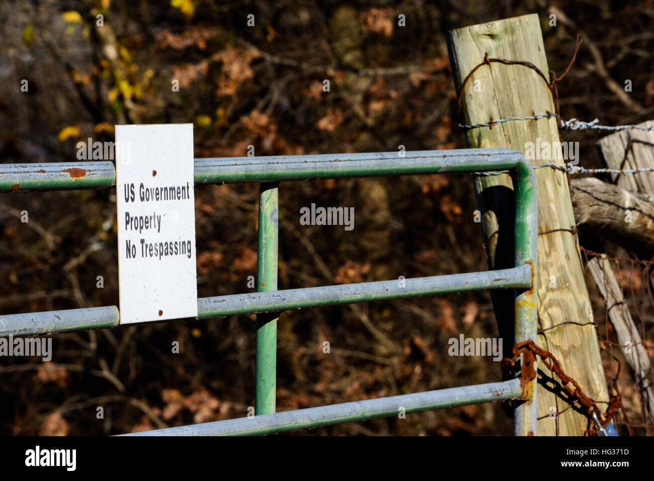 US Government Property sign on locked gate with thick woods in ...