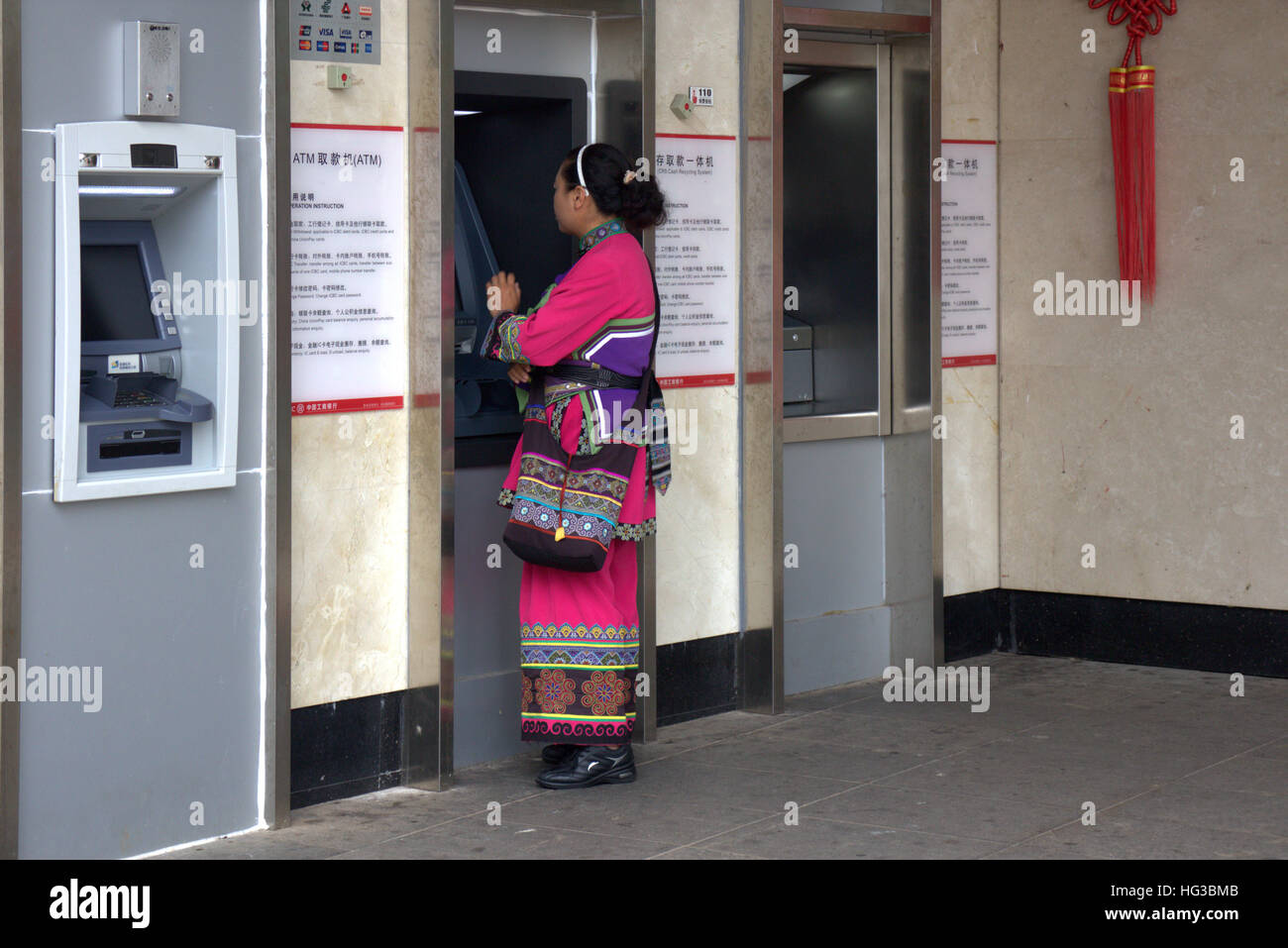 China, Yunnan, Shilin, woman wearing traditional hani costume at ATM ...