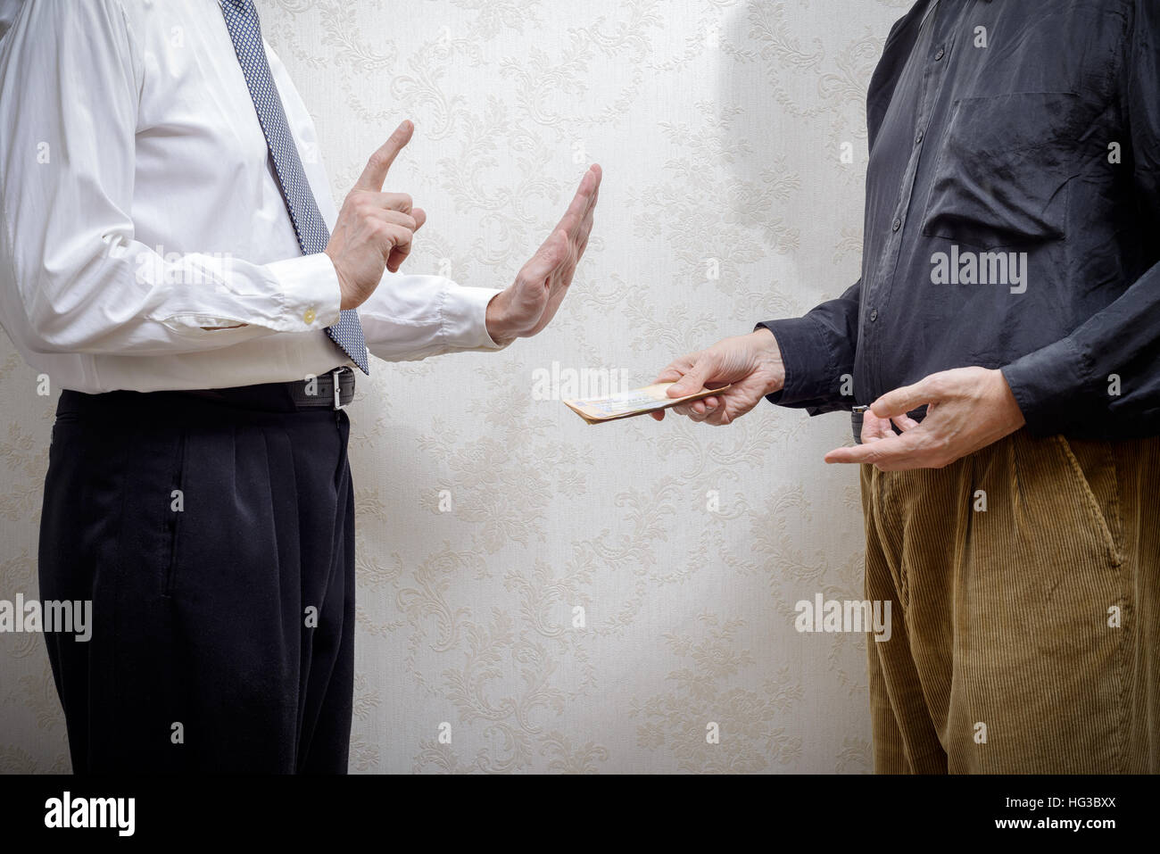 Corrupted man offering a Hryvnia banknotes bribe to a businessman, or ...