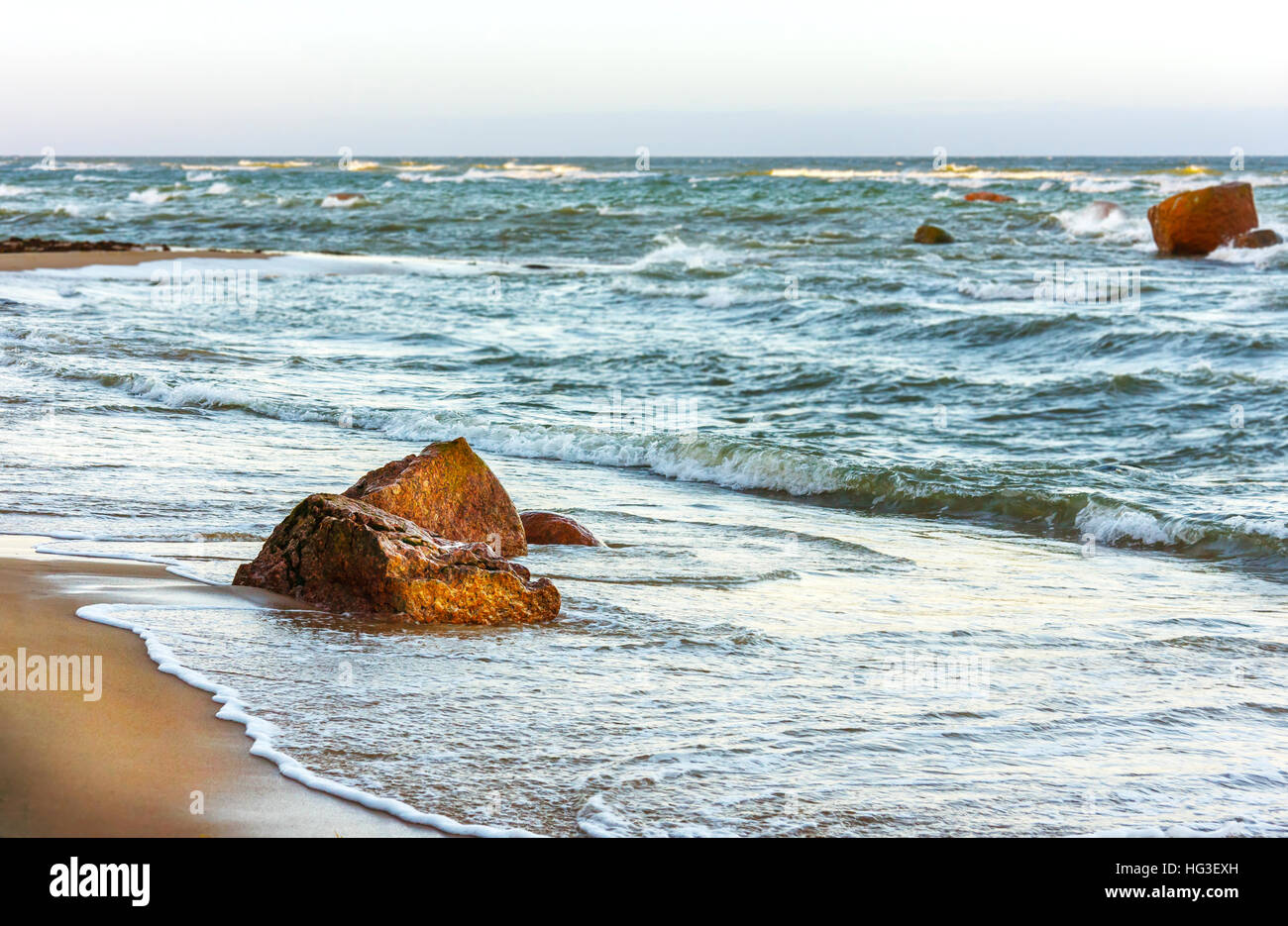Stormy seascape of several rocks in a turbulent ocean, sandy beach at ...