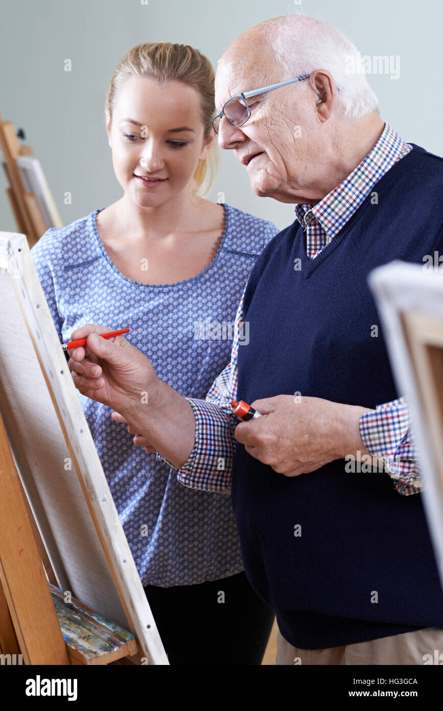Senior Man Attending Painting Class With Teacher Stock Photo - Alamy