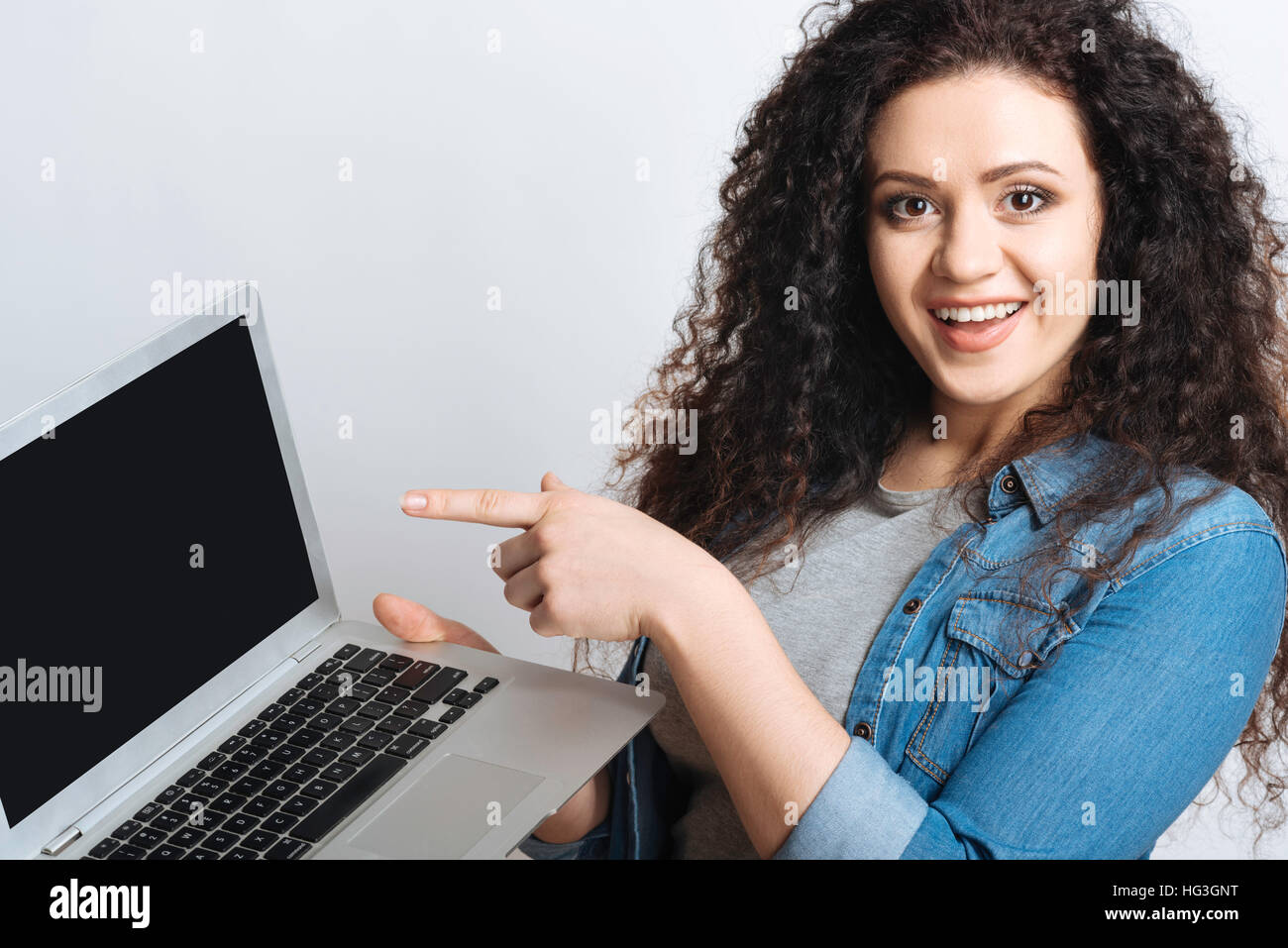 Smiling girl advertising a laptop Stock Photo - Alamy