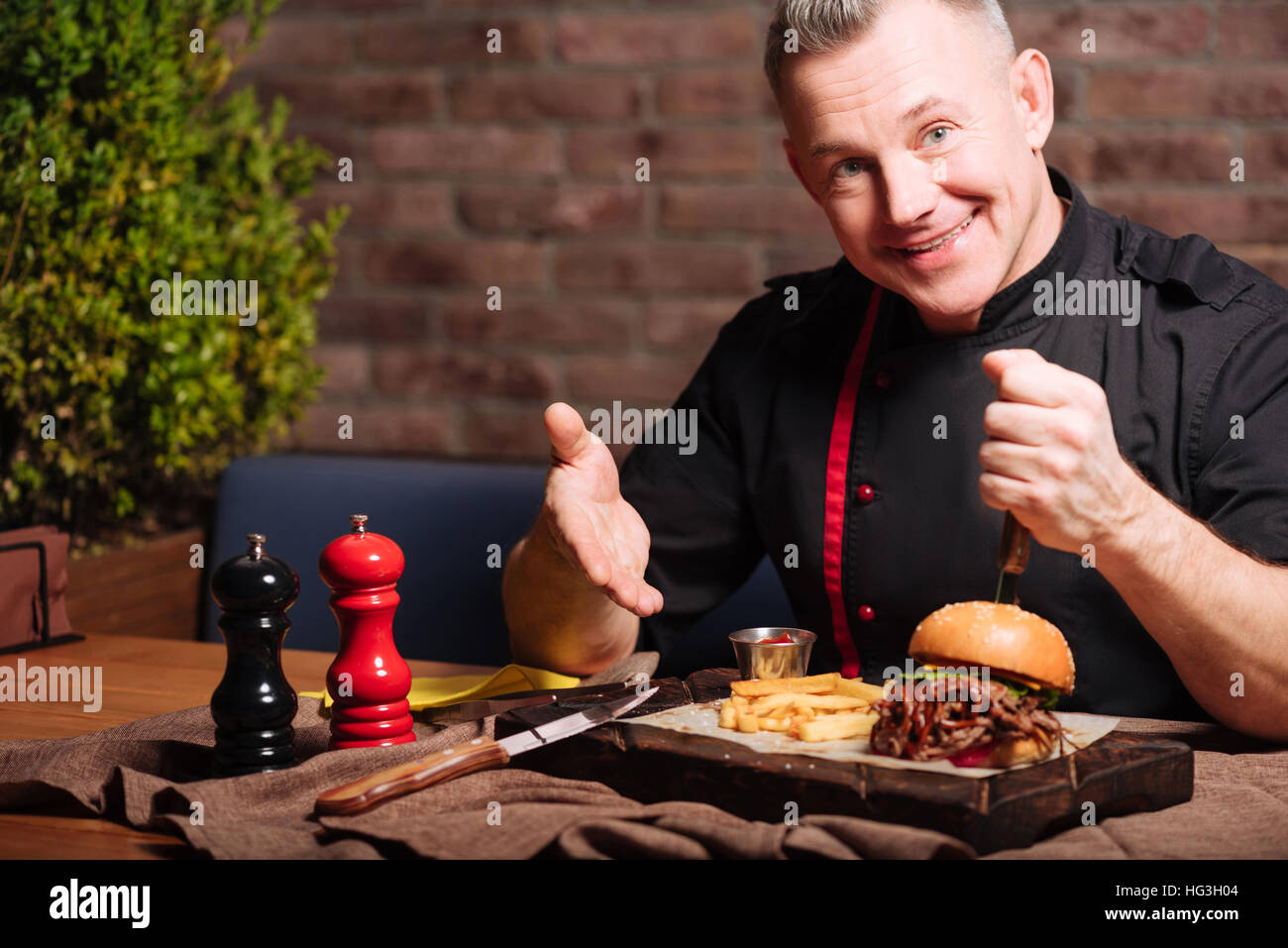 Happy man eating burger in restaurant Stock Photo - Alamy