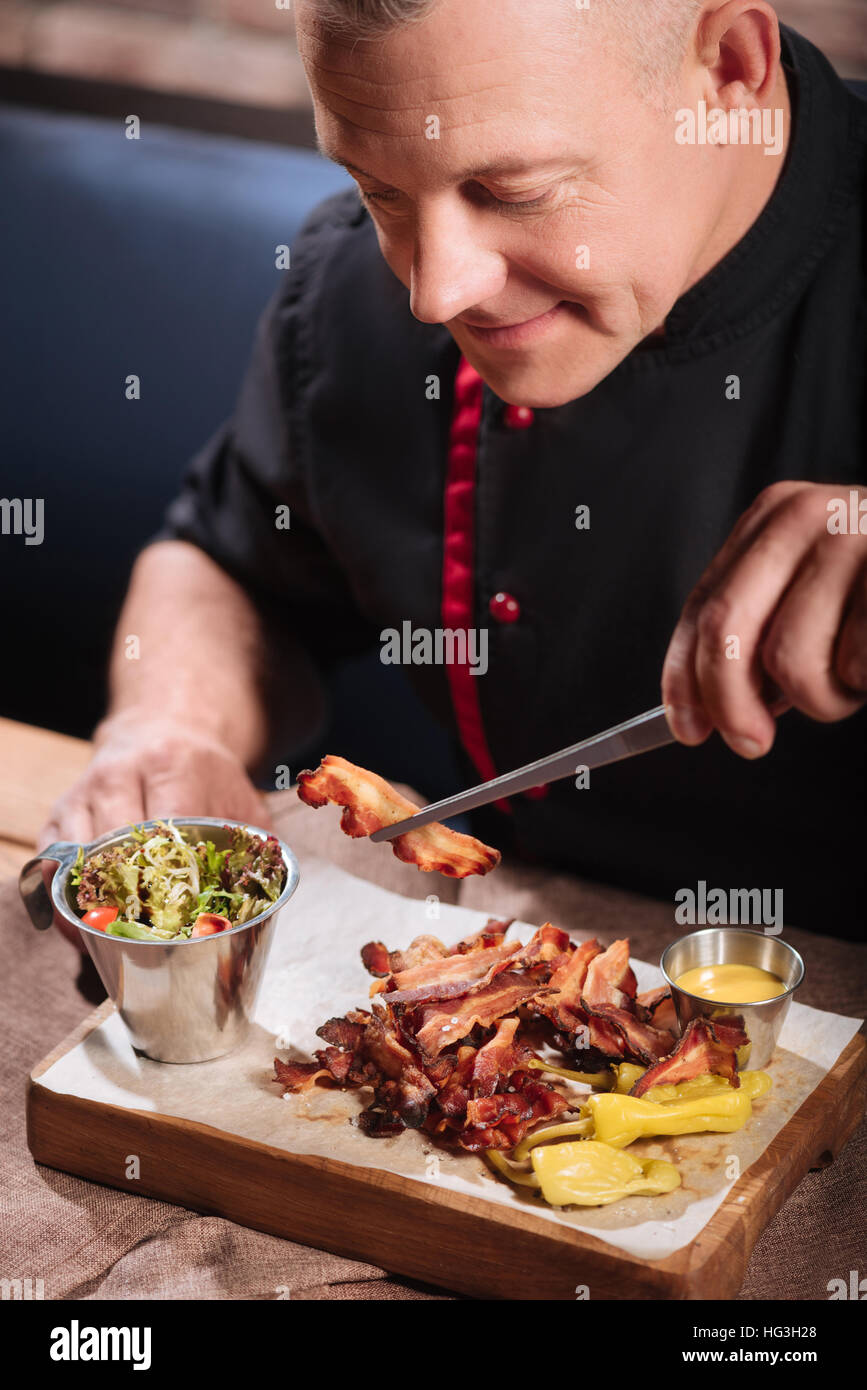 Overjoyedman eating bacon in restaurant Stock Photo - Alamy