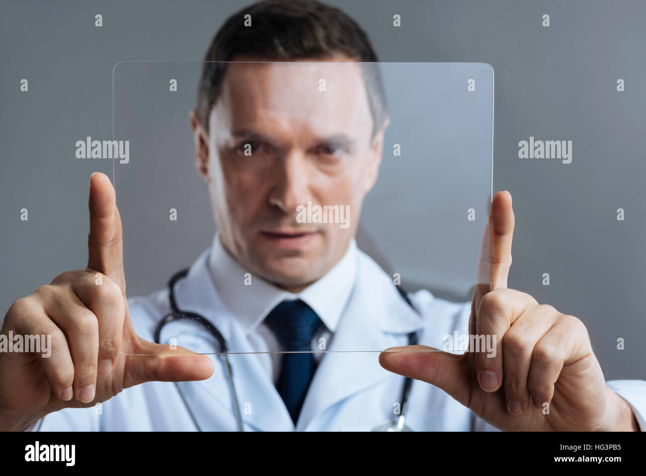 Handsome doctor posing with medical glass Stock Photo - Alamy
