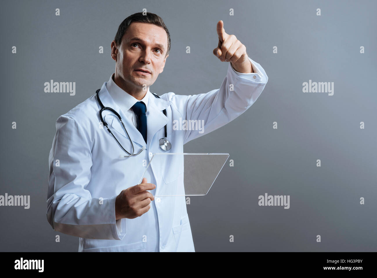 Handsome doctor pointing somewhere with his finger Stock Photo - Alamy