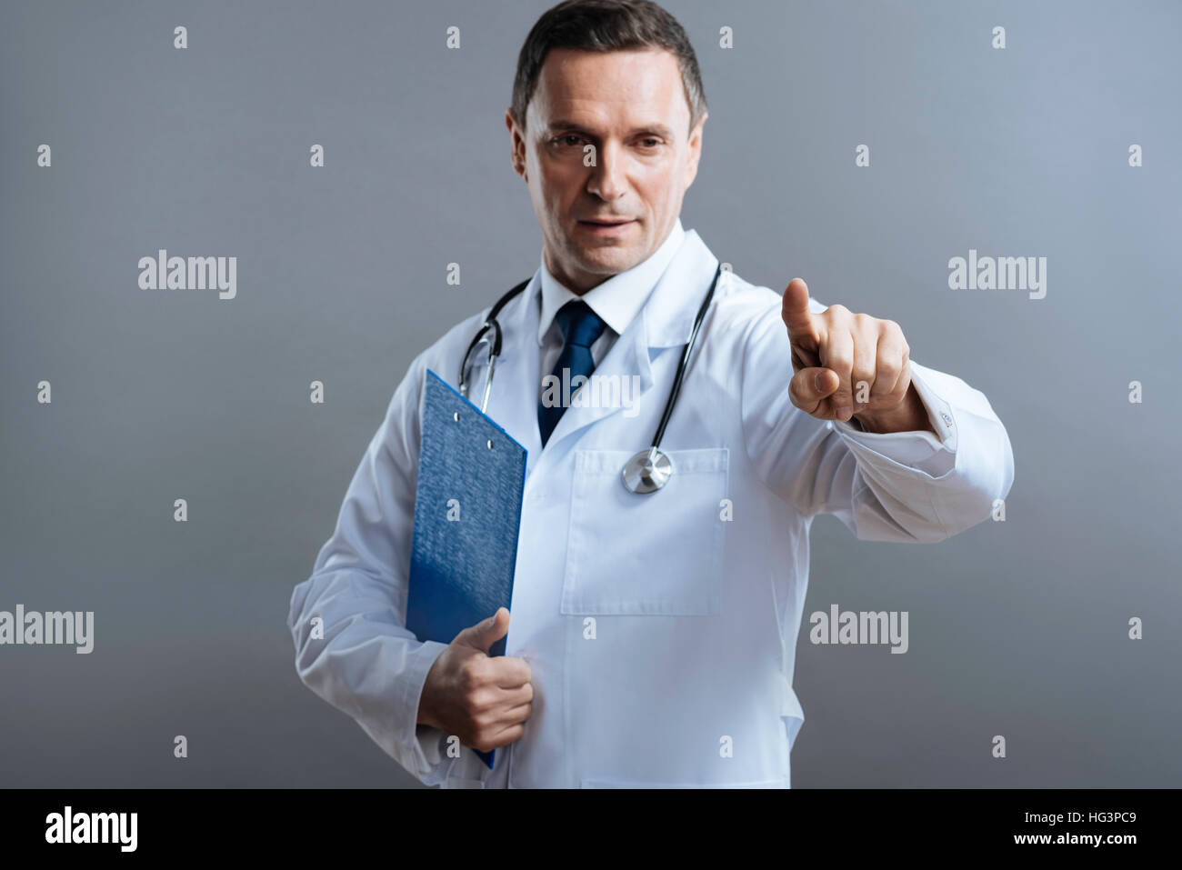 Handsome doctor pointing with his finger Stock Photo - Alamy
