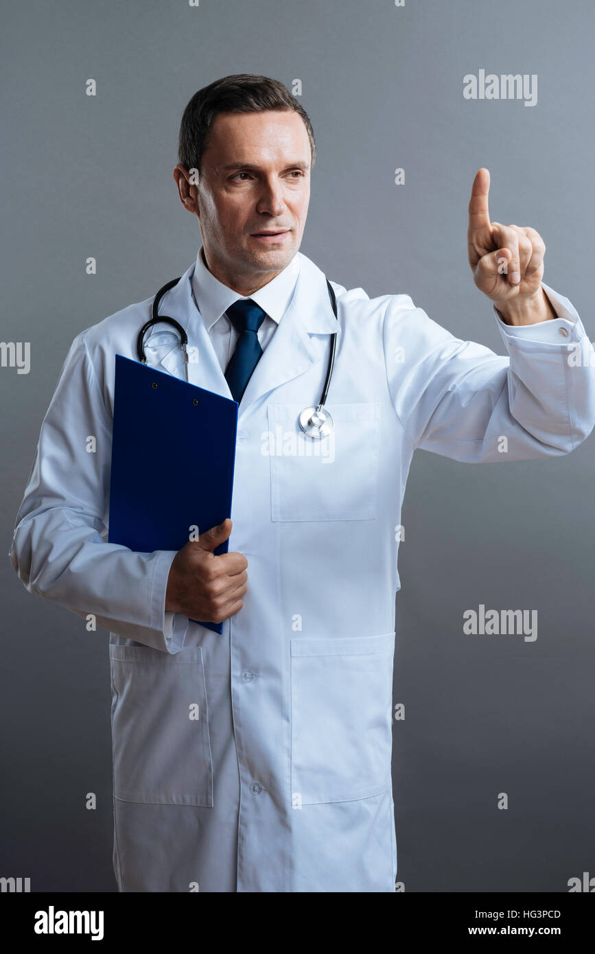 Confident doctor pointing his finger up Stock Photo - Alamy