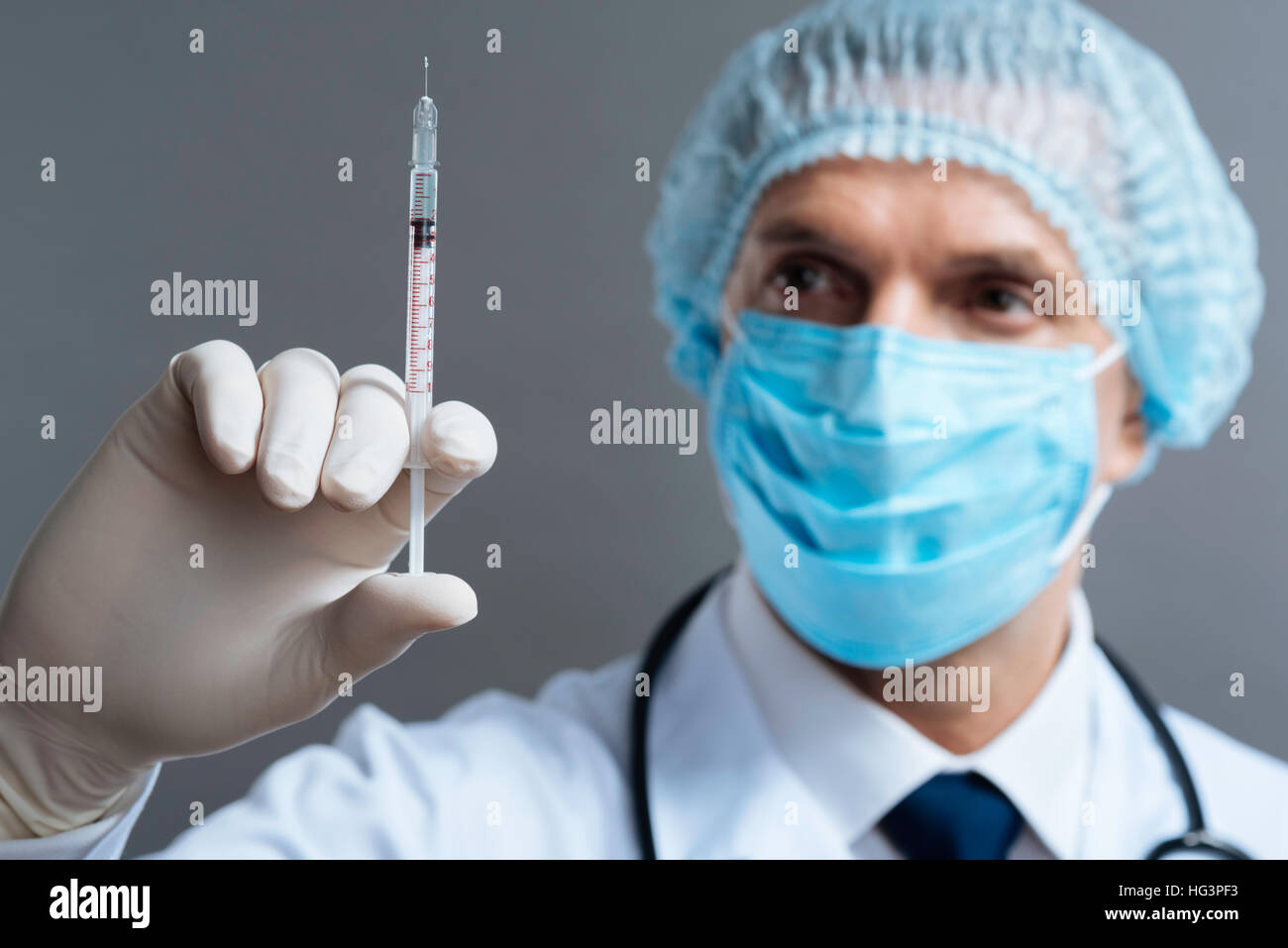 Handsome doctor holding hypodermic needle Stock Photo - Alamy