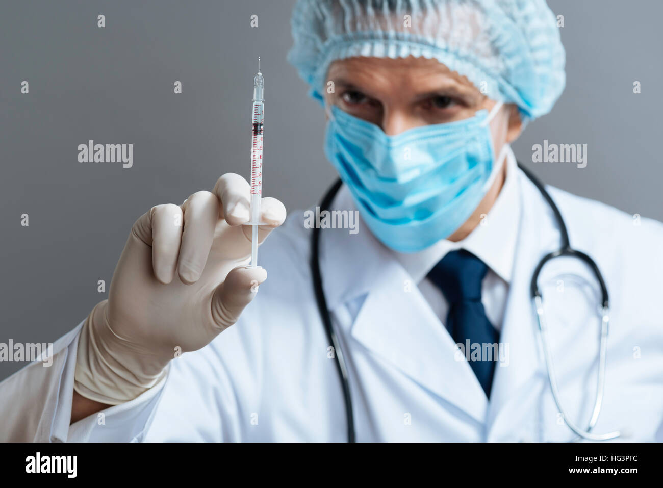 Delighted doctor holding hypodermic needle Stock Photo - Alamy