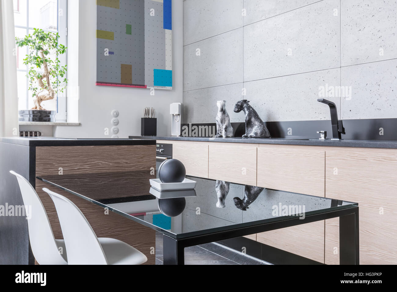 Black kitchen table, two chairs and long worktop Stock Photo - Alamy
