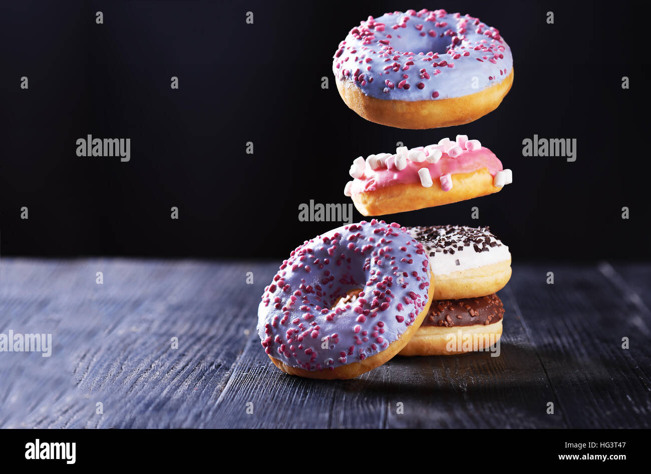Falling donuts on a dark background Stock Photo - Alamy