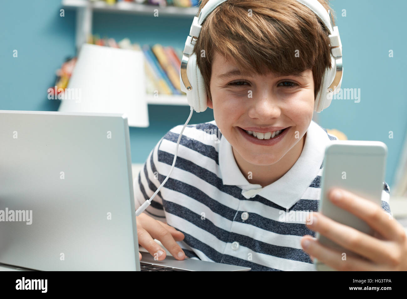 Teenage Boy Using Technology In Bedroom Stock Photo - Alamy