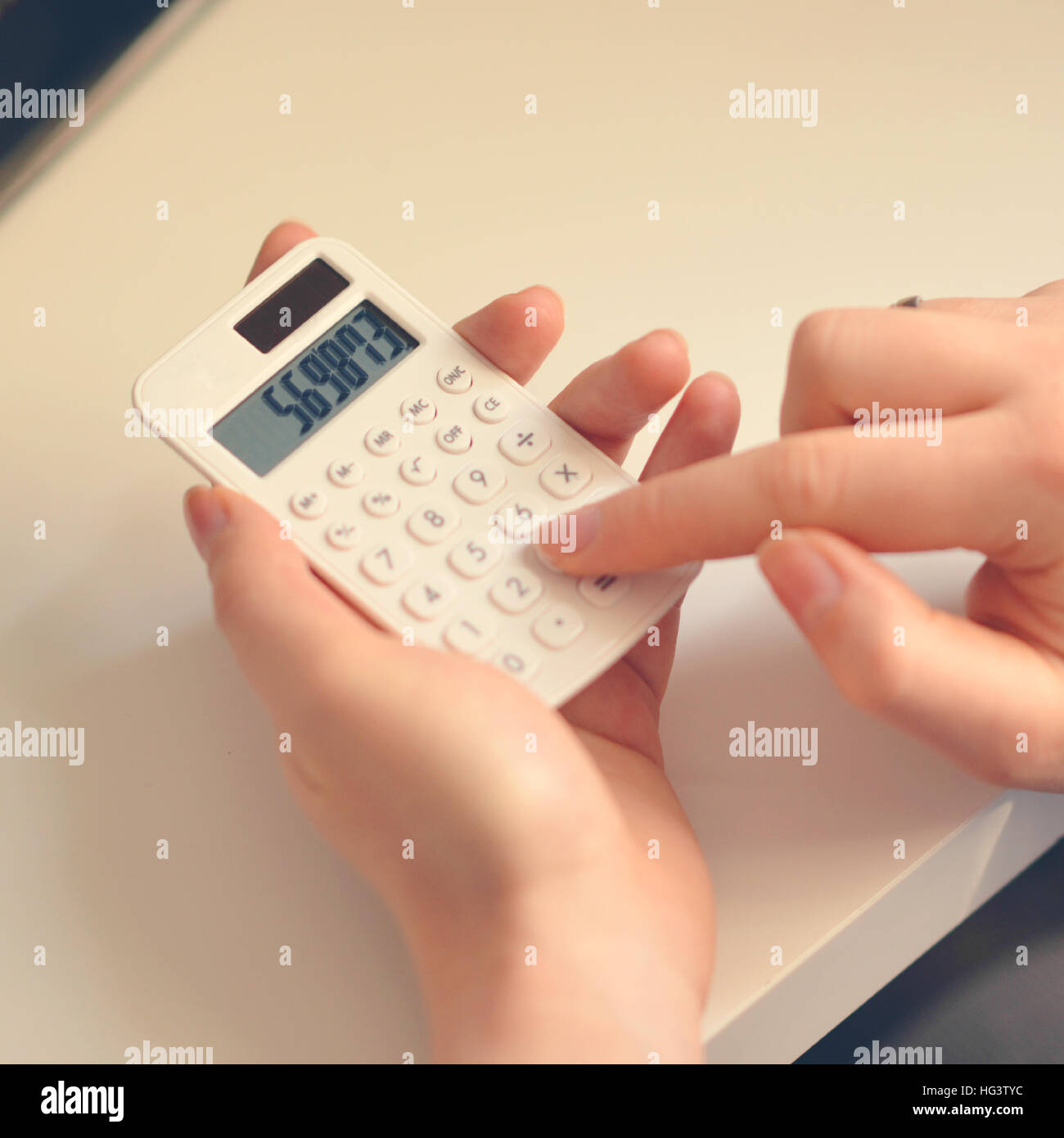 Woman doing calculations on calcualtor Stock Photo - Alamy