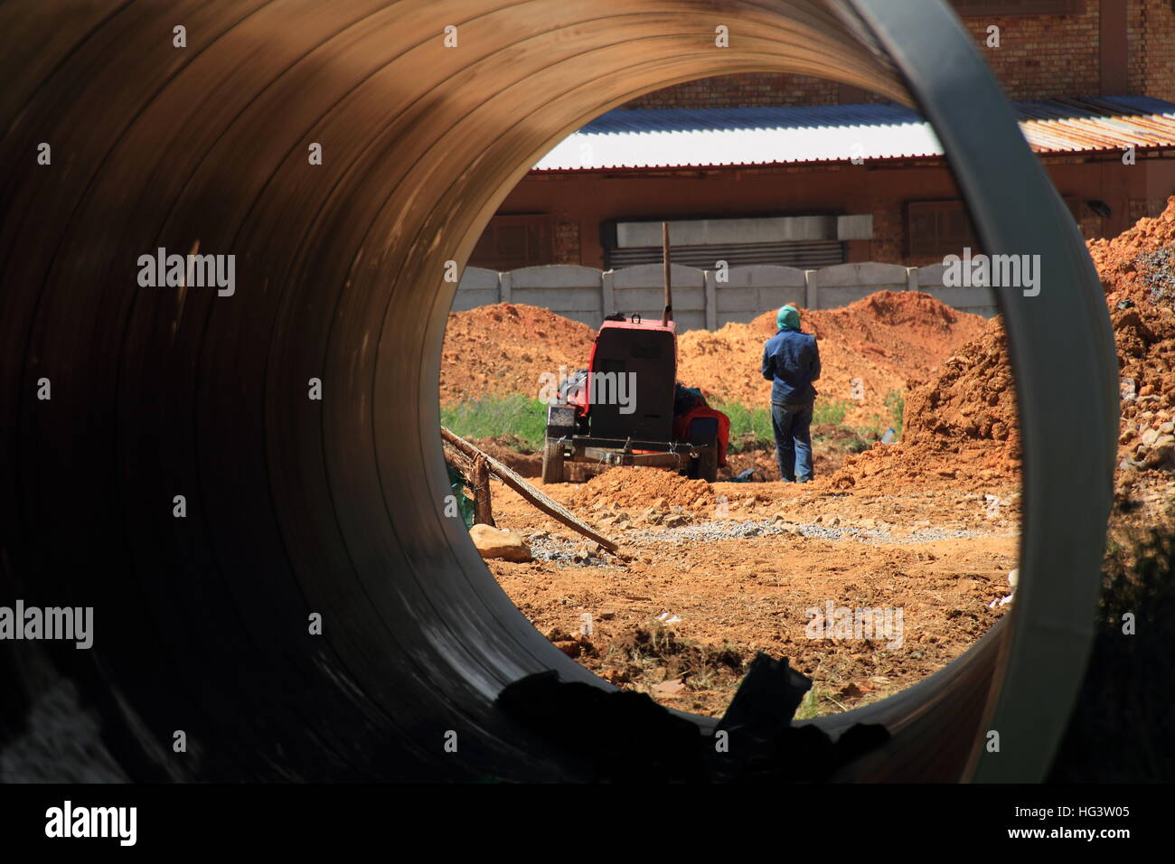 View through a large metal pipe on a civil construction site image with ...