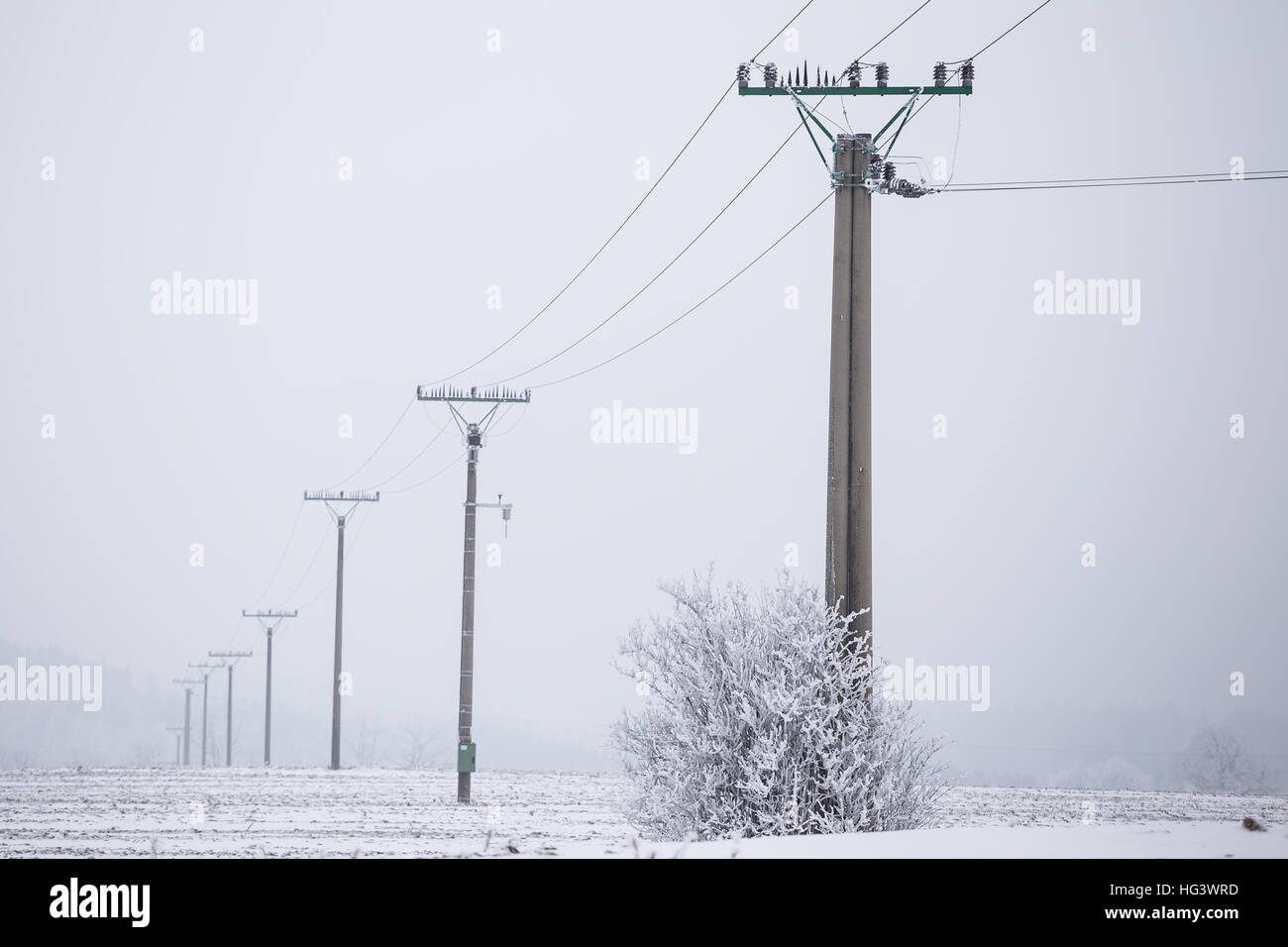 Electrical pylons high voltage wires in winter covered snow and ice ...