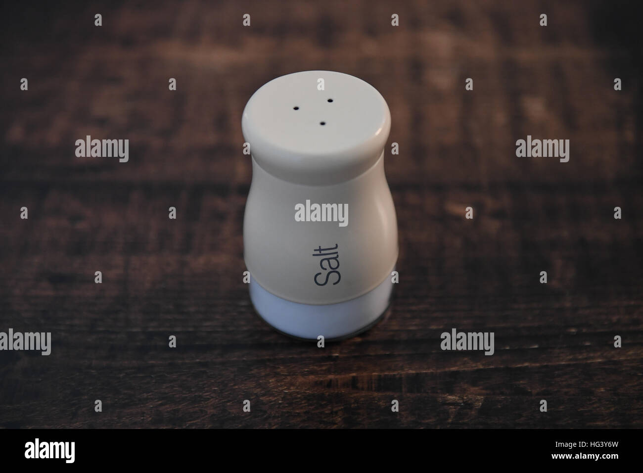 Salt shaker/pot filled with salt on a dark hardwood table Stock Photo ...