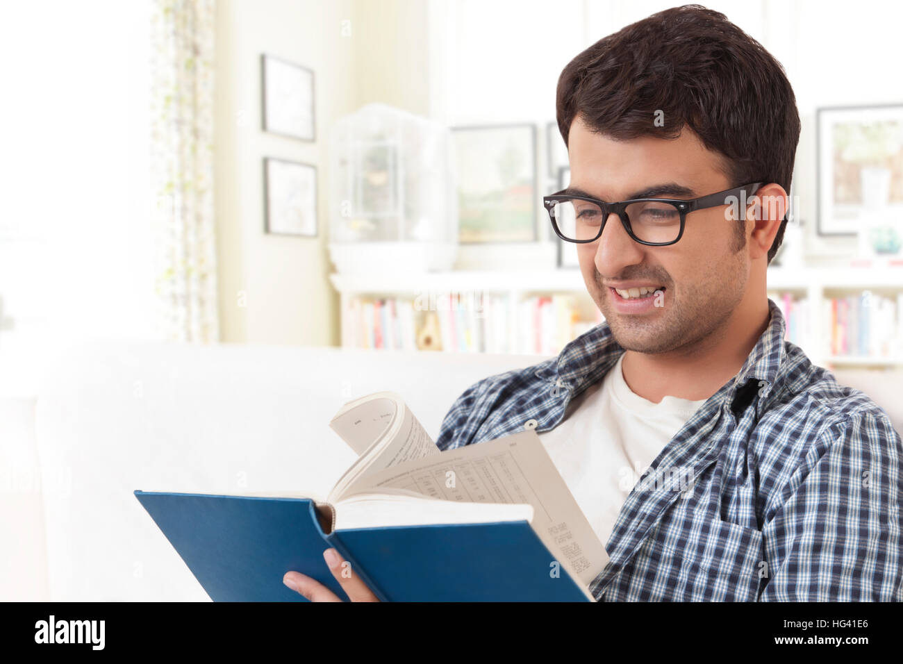 Smiling young man reading hi-res stock photography and images - Alamy