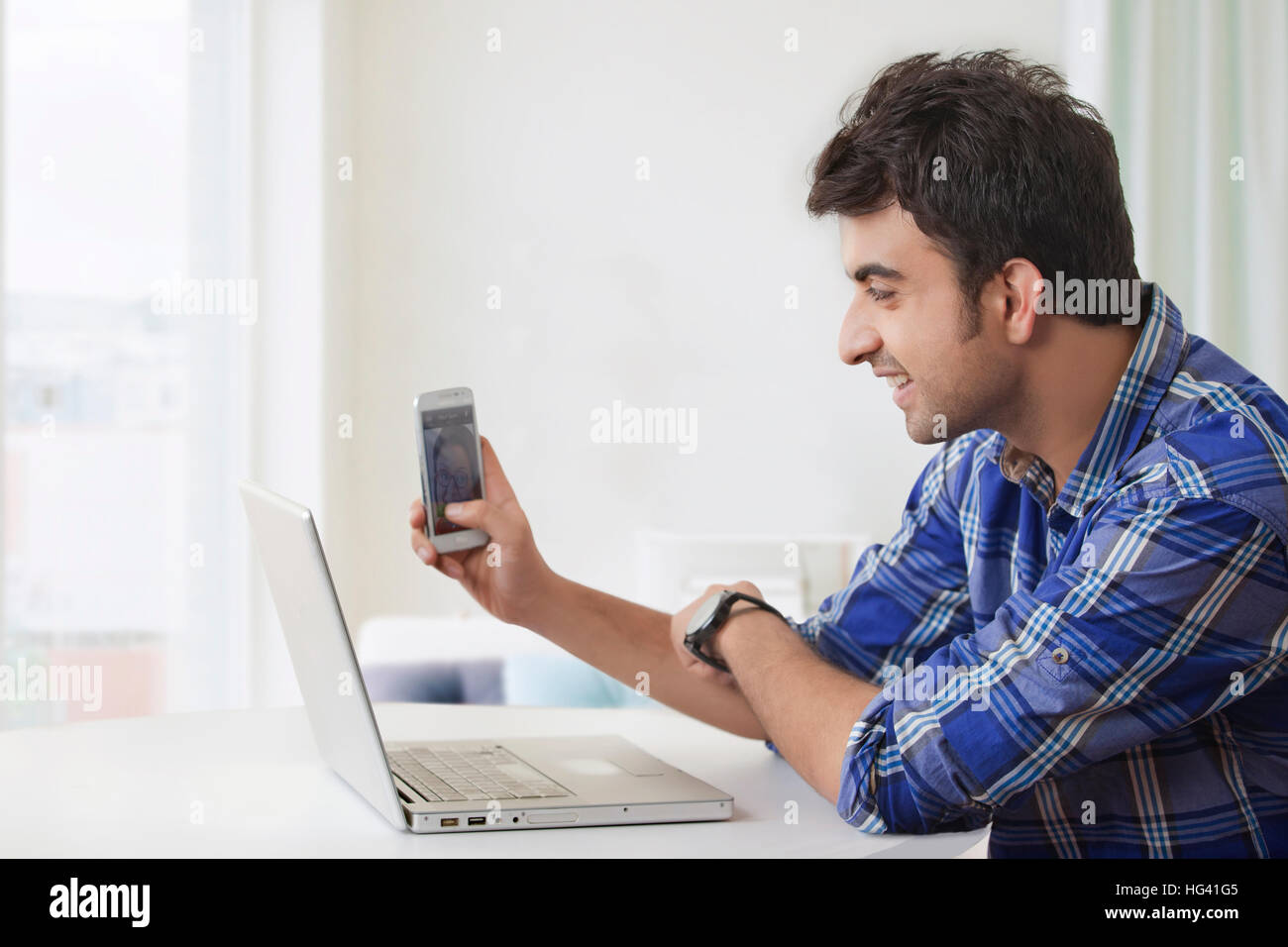 Smiling man having video calling on phone Stock Photo - Alamy