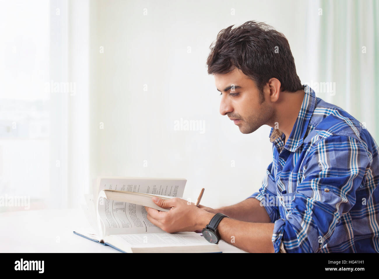 Young man studying and making notes Stock Photo - Alamy
