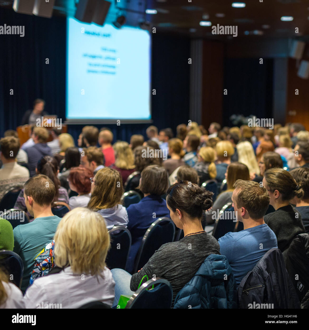 Audience in lecture hall participating at business event Stock Photo ...