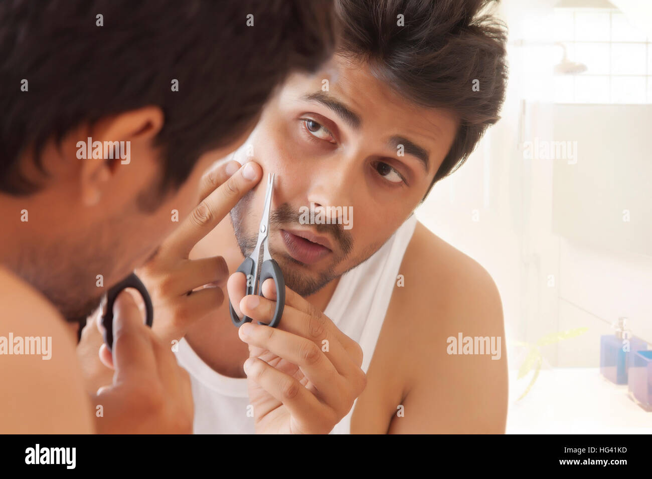 Man grooming his beard with scissors Stock Photo - Alamy