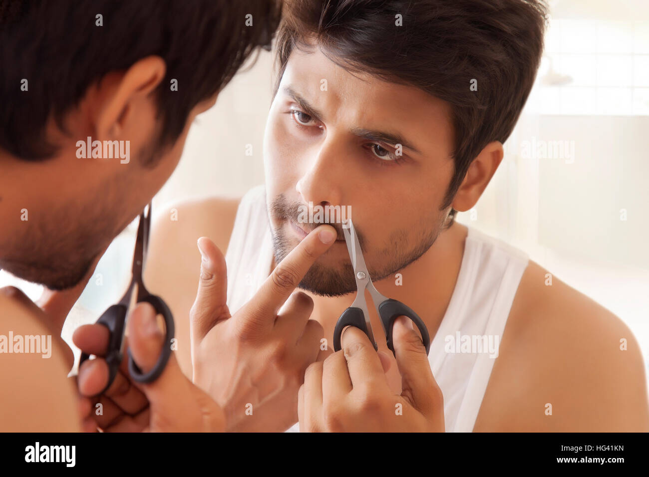 Man grooming his beard with scissors Stock Photo - Alamy