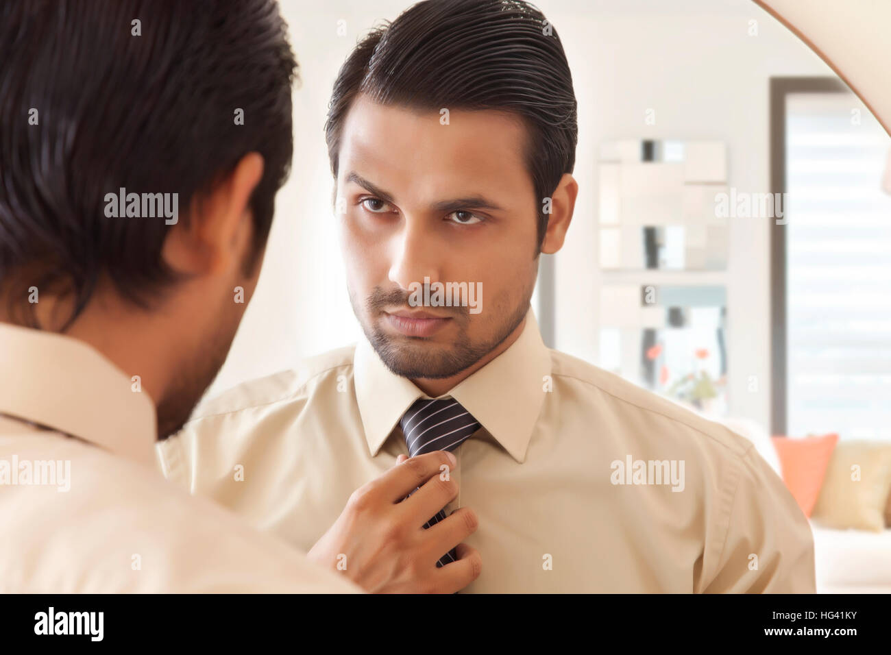 Businessman looking at self in mirror Stock Photo - Alamy