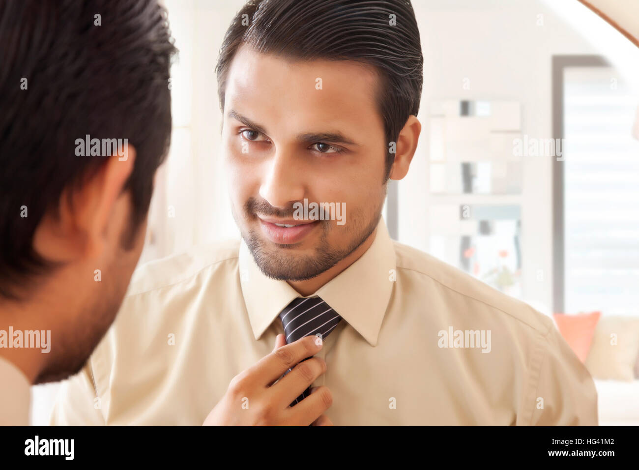 Businessman looking at self in mirror Stock Photo - Alamy
