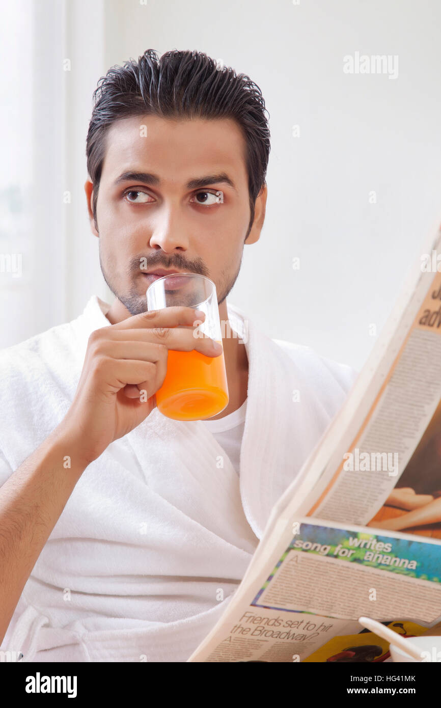 Portrait of man drinking juice holding newspaper Stock Photo - Alamy