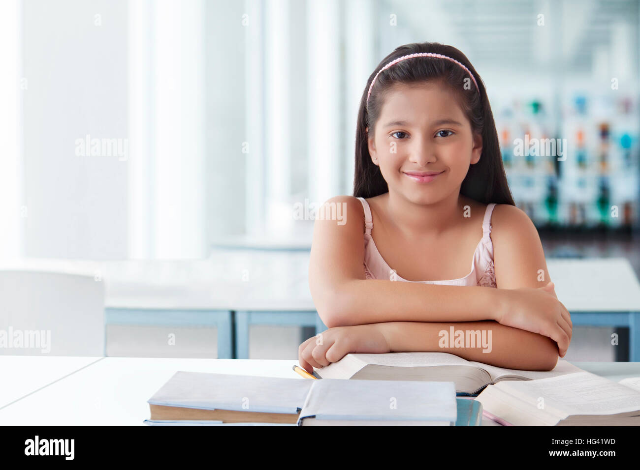 Portrait of cute girl at desk with books Stock Photo - Alamy