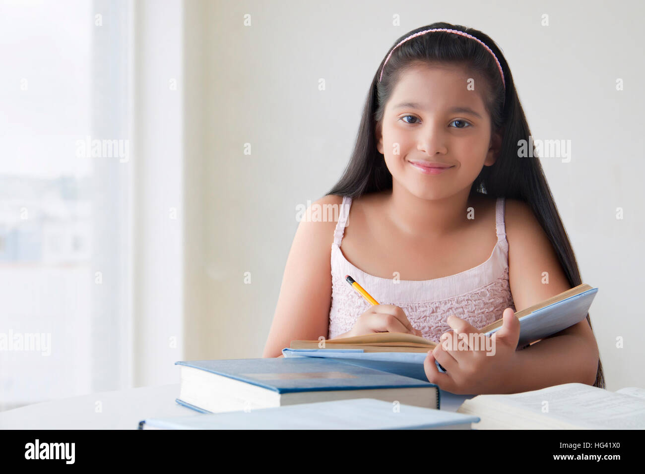 Portrait of cute girl doing homework Stock Photo - Alamy