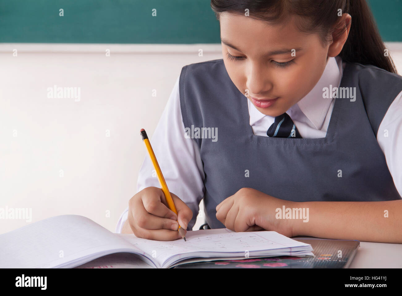 Girl writing notes in a classroom Stock Photo - Alamy