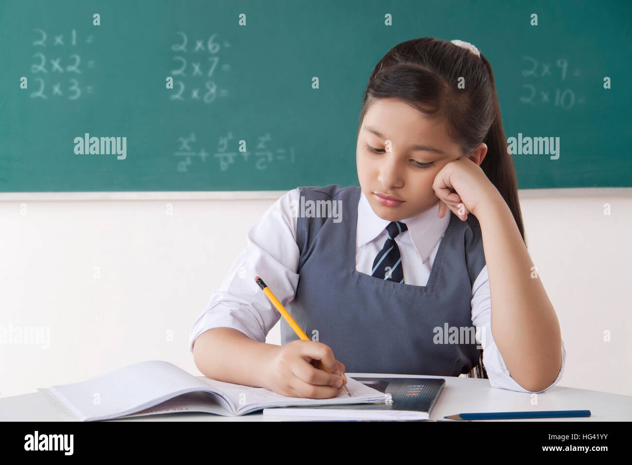 Girl writing notes in a classroom Stock Photo - Alamy