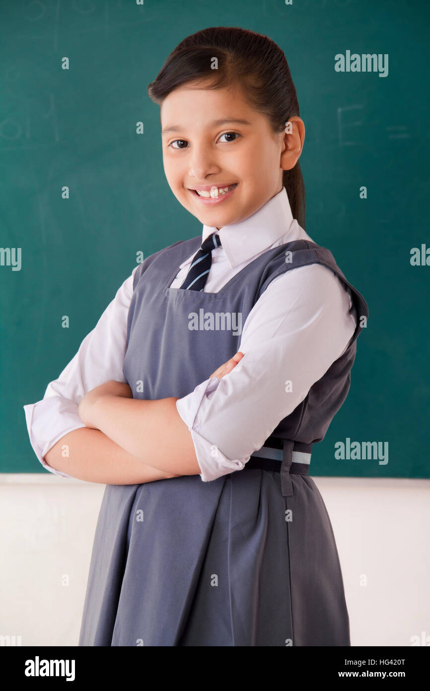 Portrait of girl smiling with her arms crossed standing in front of a ...