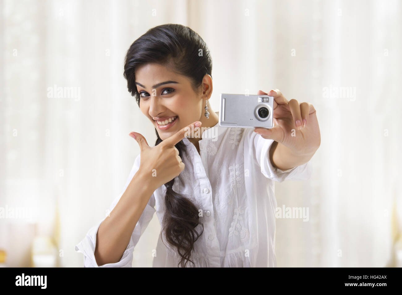 Young woman taking photograph with camera showing smiley face Stock ...