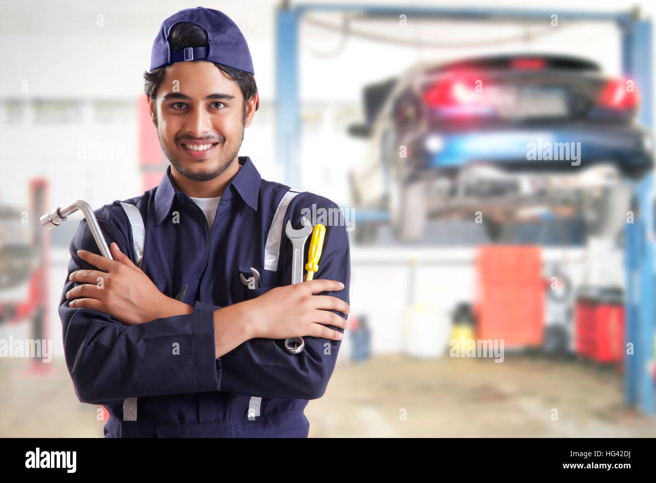Portrait of car mechanic with hand tools in garage Stock Photo - Alamy