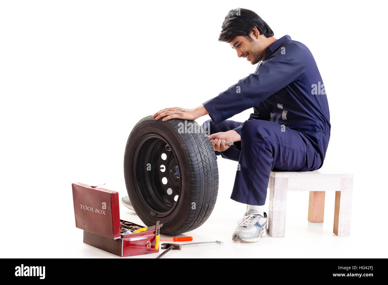 Portrait of mechanic repairing tyre Stock Photo - Alamy