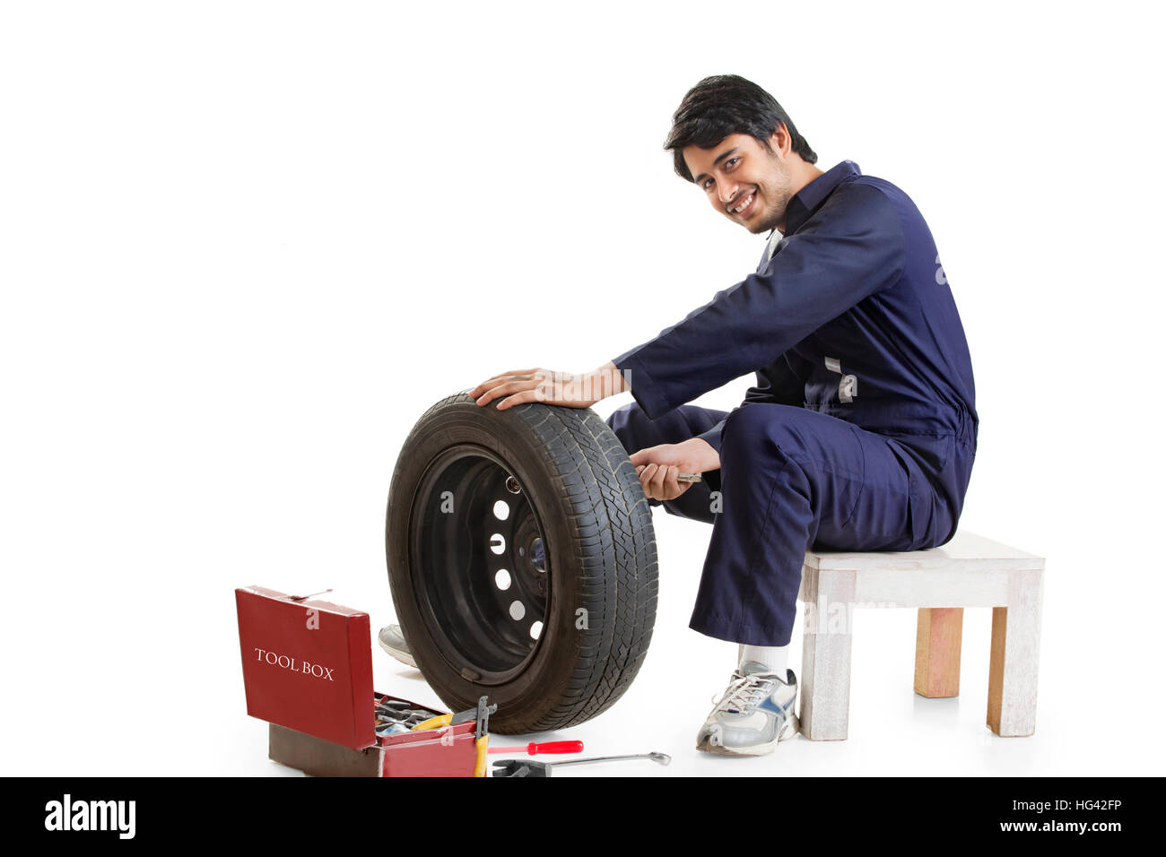 Portrait of mechanic repairing tyre Stock Photo - Alamy