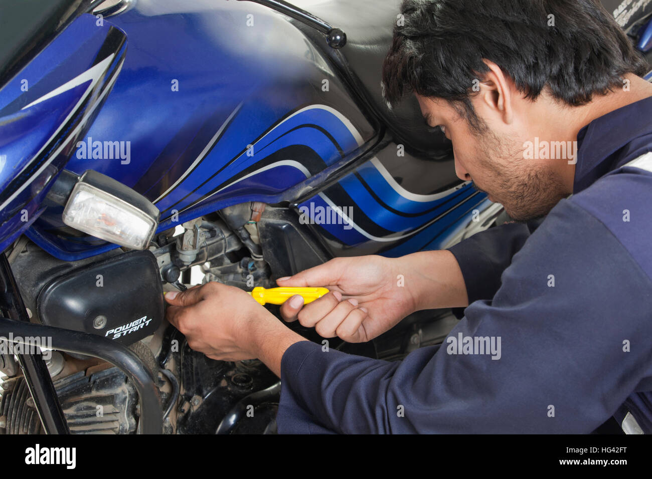 Mechanic repairing motorcycle Stock Photo - Alamy