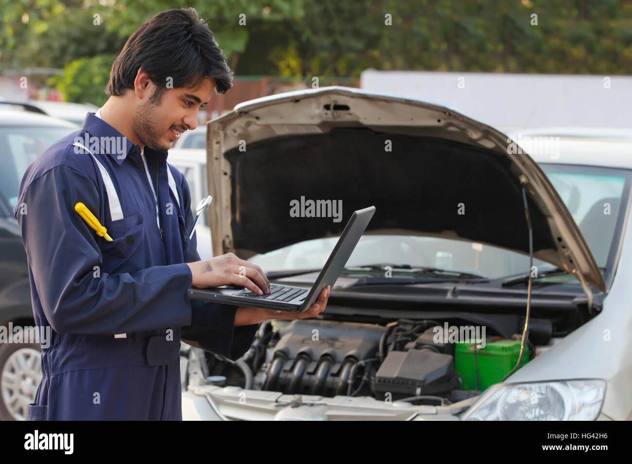 Mechanic using laptop in garage Stock Photo - Alamy